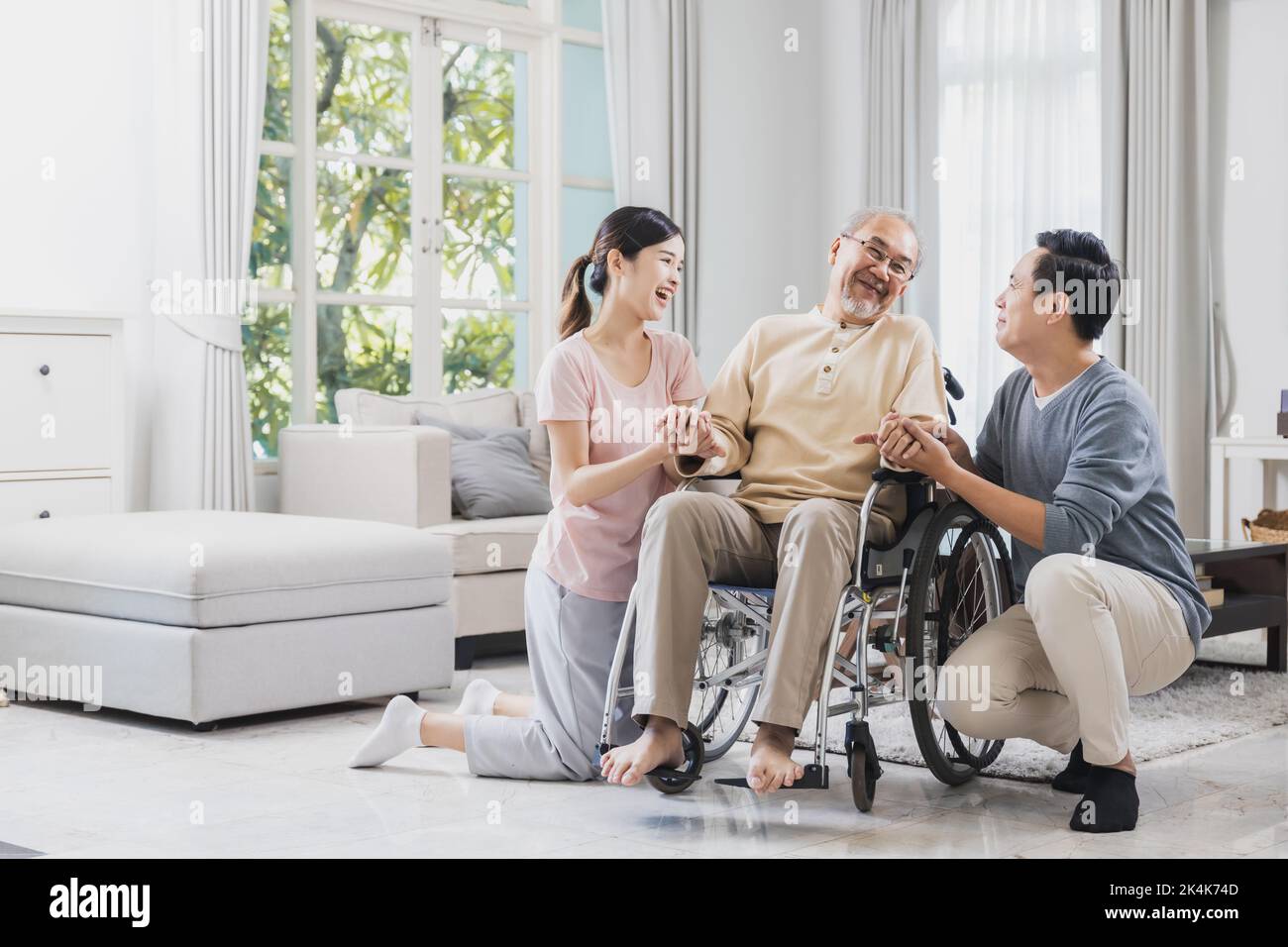 Happy Asian family of senior with beautiful daughter, her husband and grandson take care old man ...