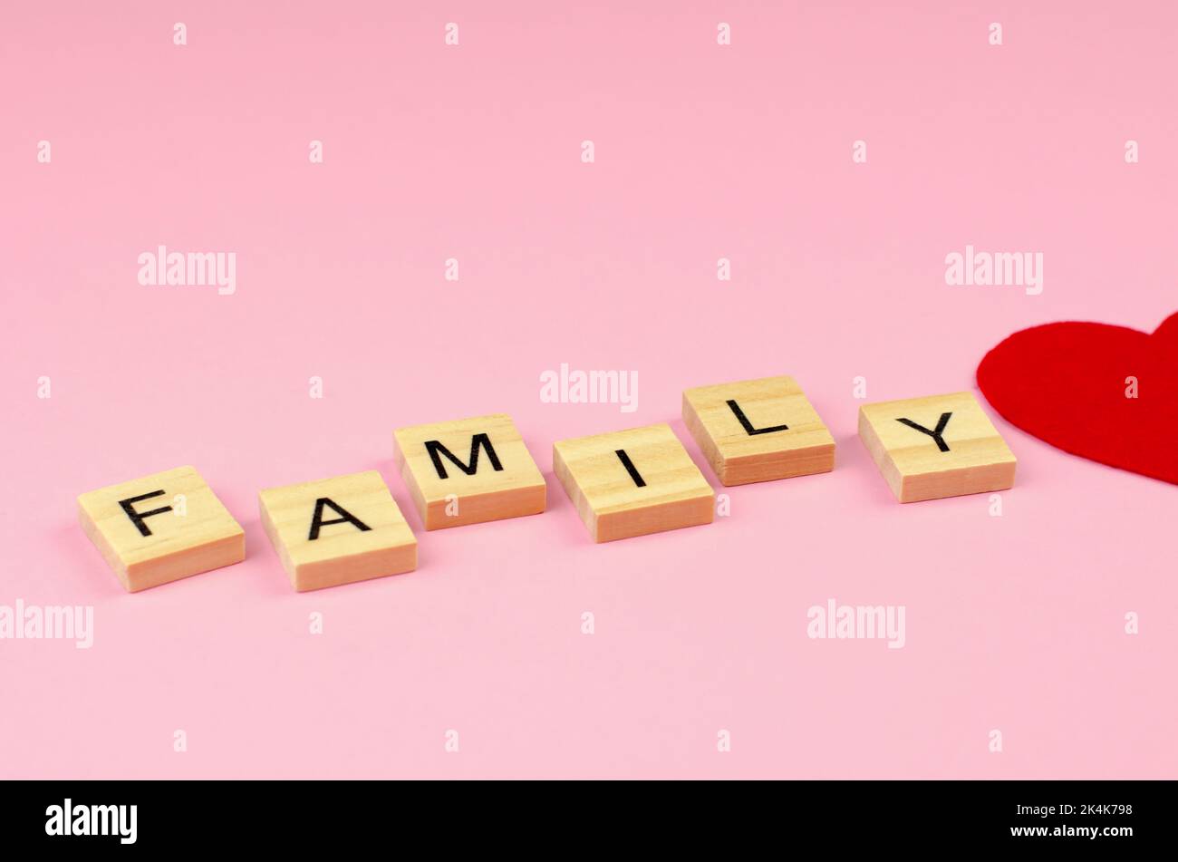 The word family made up of wooden letters and half a red heart on a ...