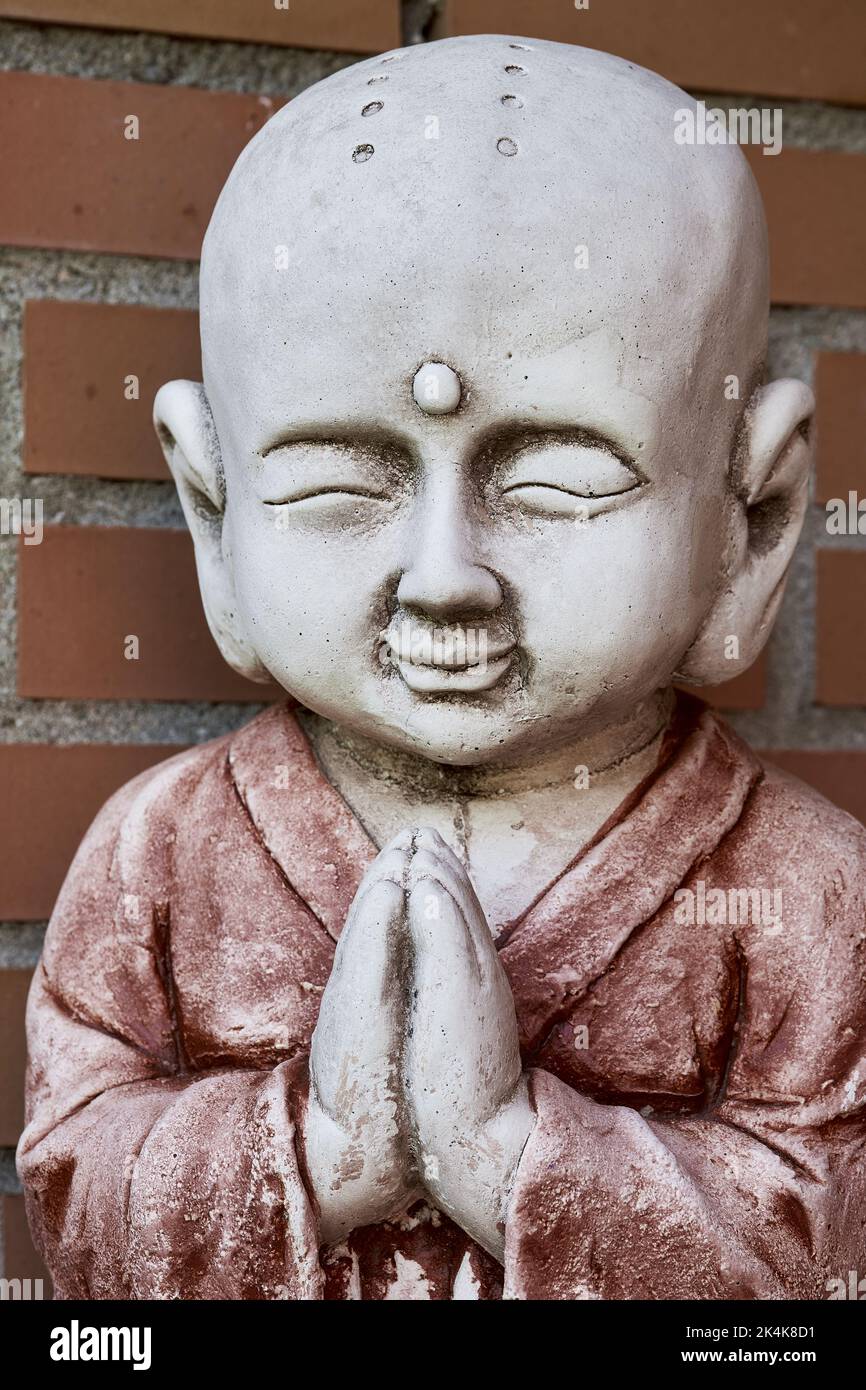 buddha kid sculpture with red brick background Stock Photo - Alamy