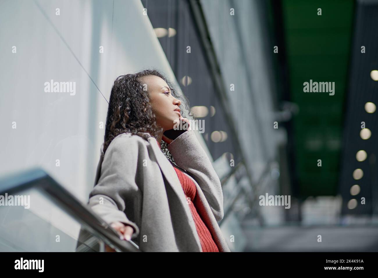 excited woman with a smartphone standing on the steps of the subway ...