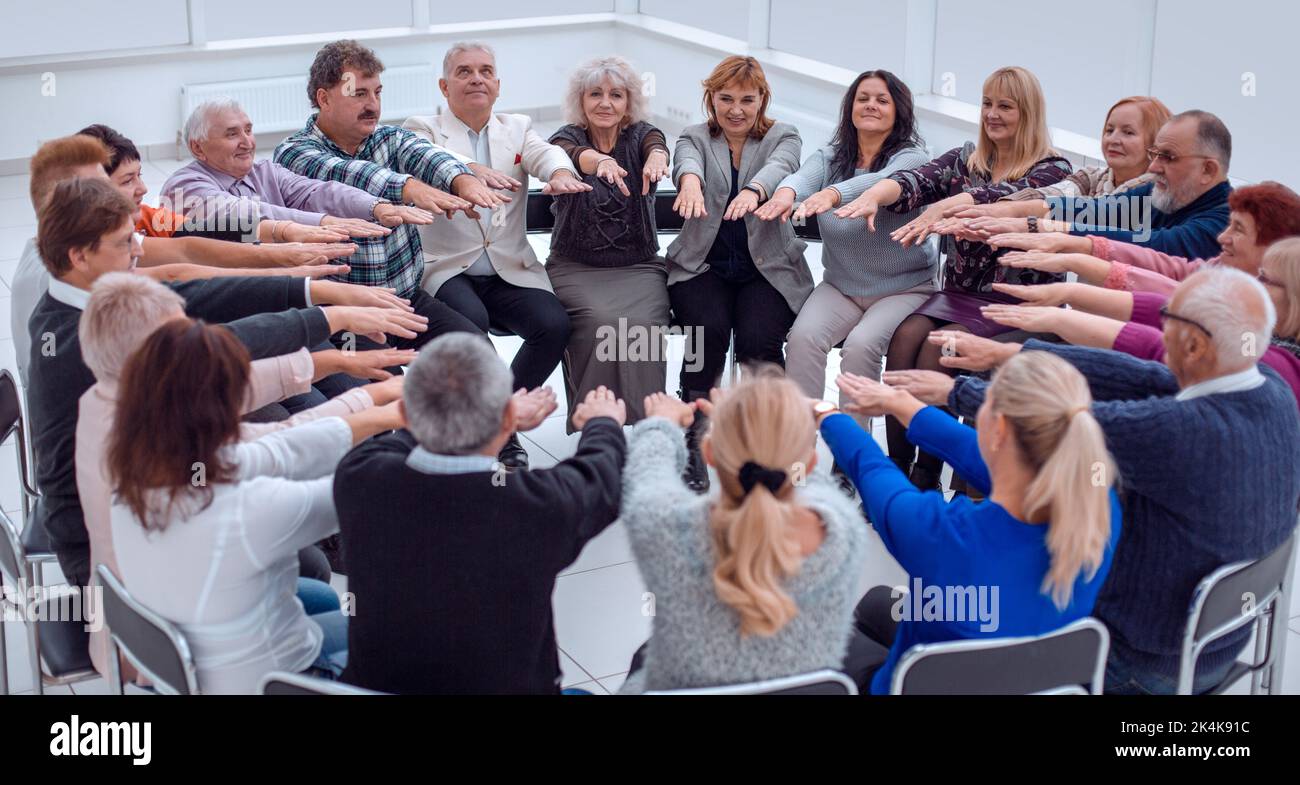 a group of mature mature people stretched their arms forward sit Stock ...