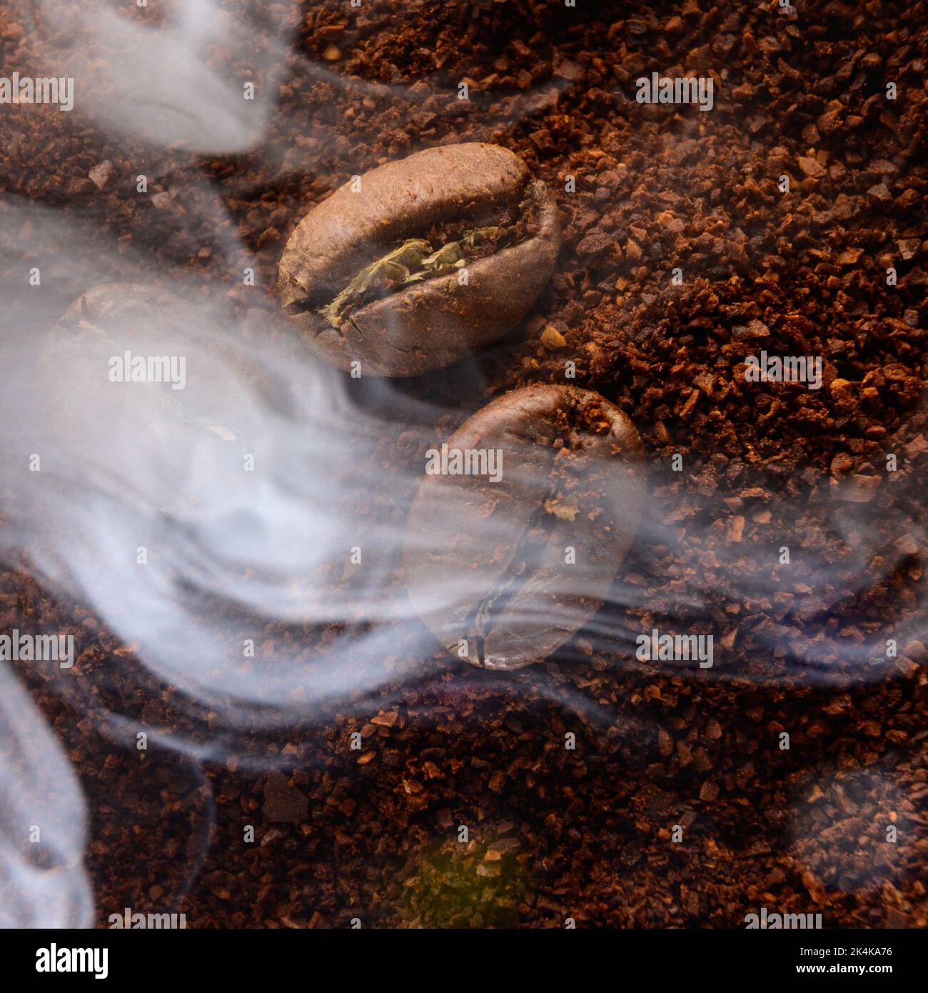 top view of coffee beans and ground coffee steaming with heat, roasted ...