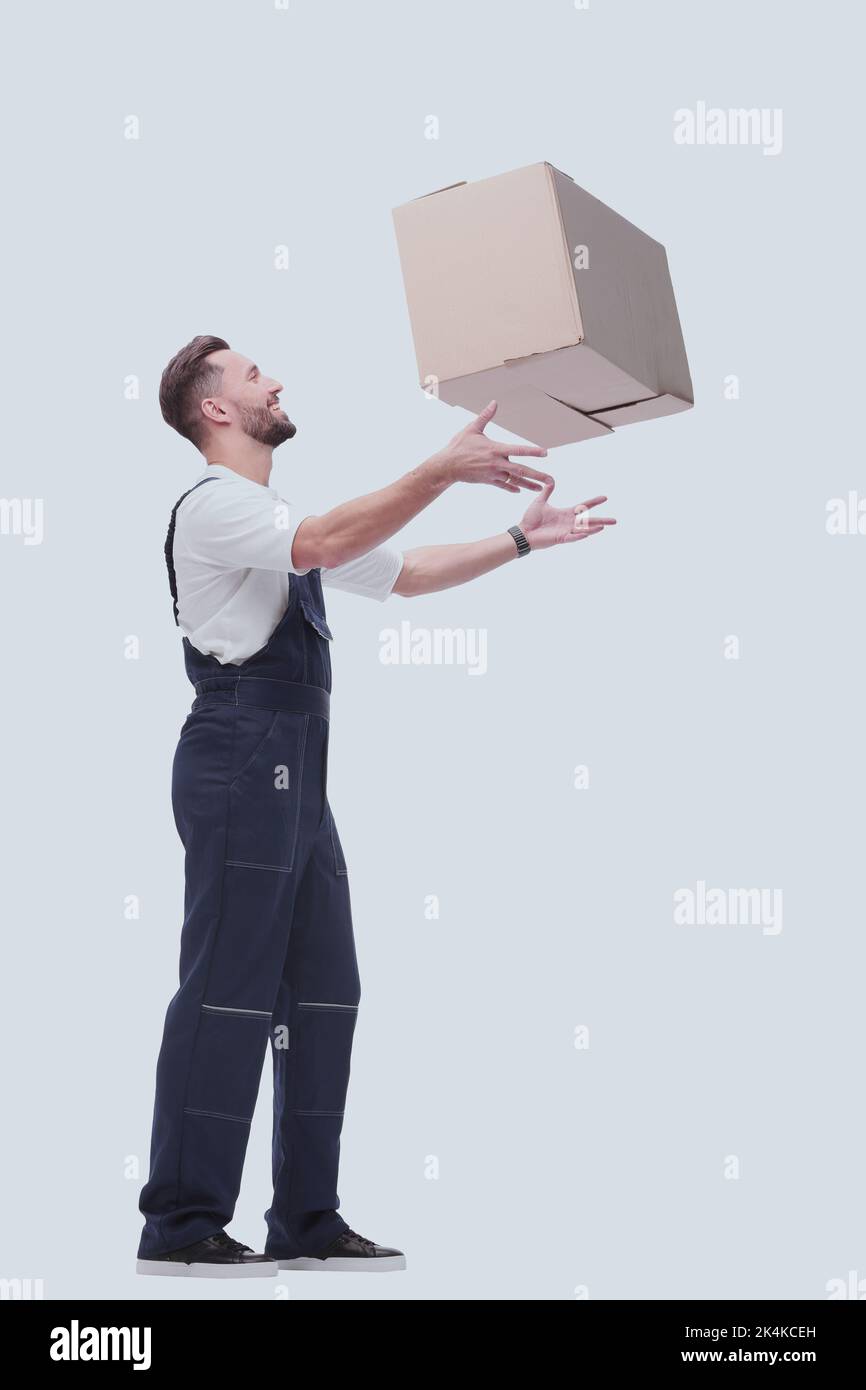 side view. smiling man in overalls catches a cardboard box Stock Photo ...