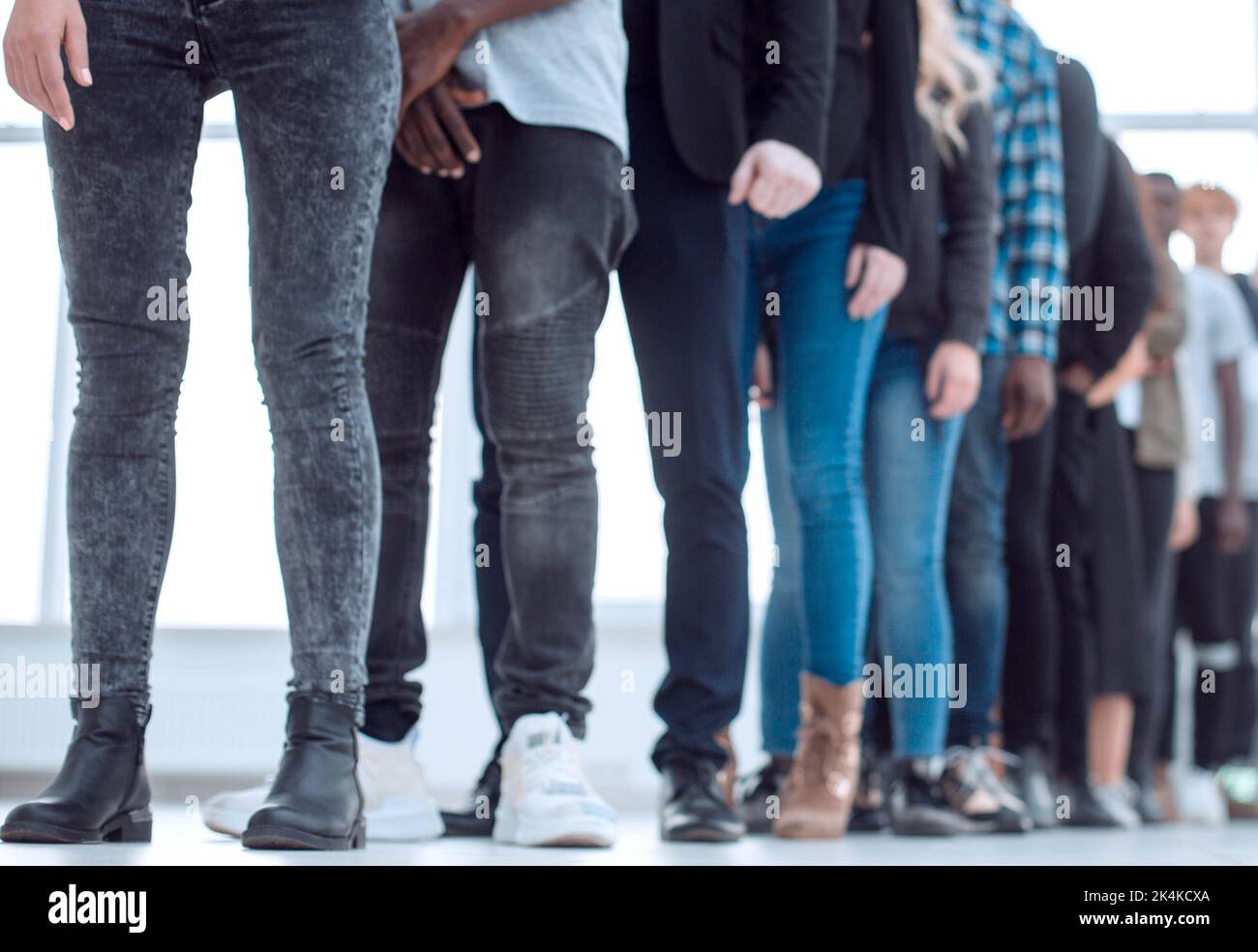 group of diverse young people standing in a queue Stock Photo - Alamy