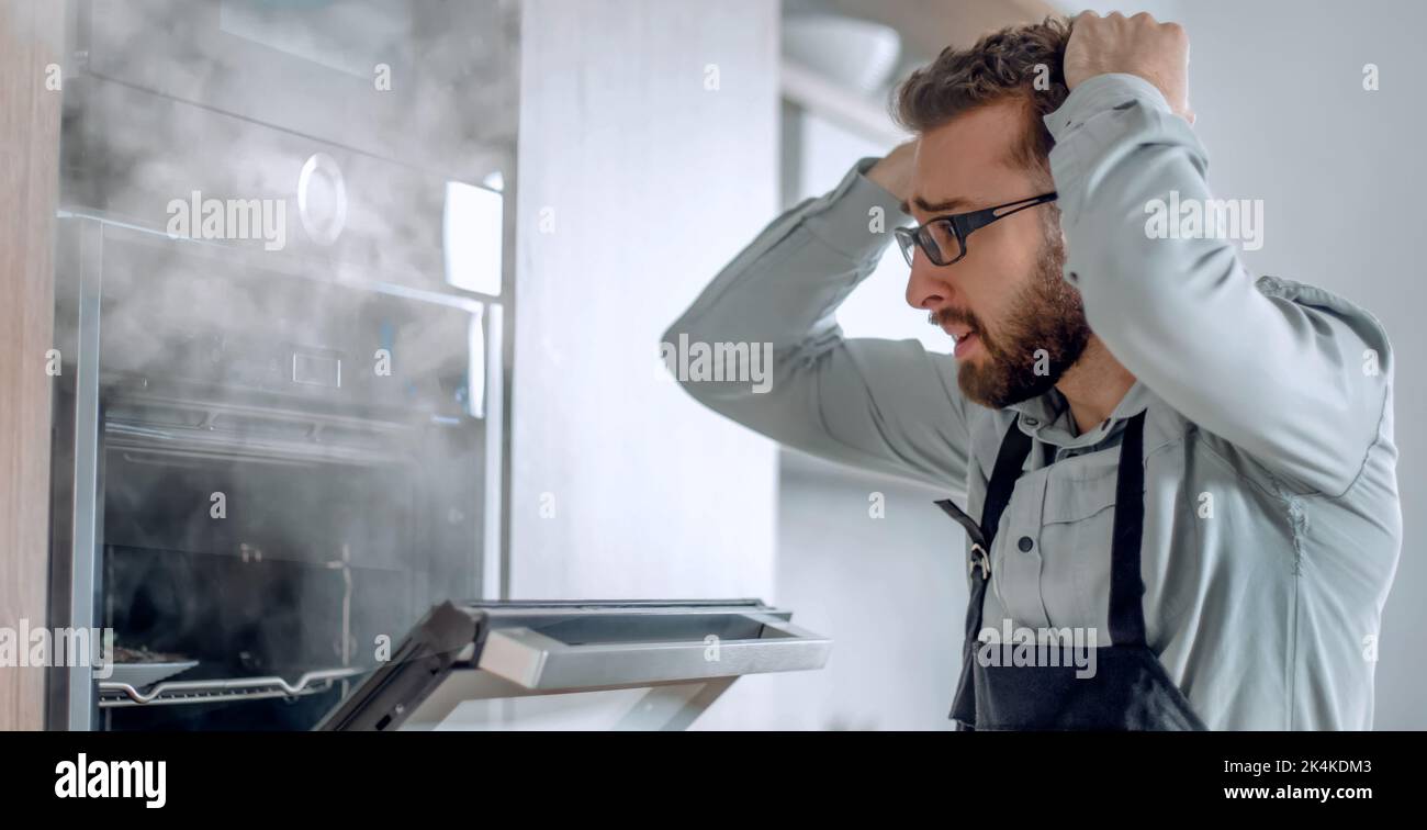 frightened man standing near an oven filled with smoke Stock Photo - Alamy