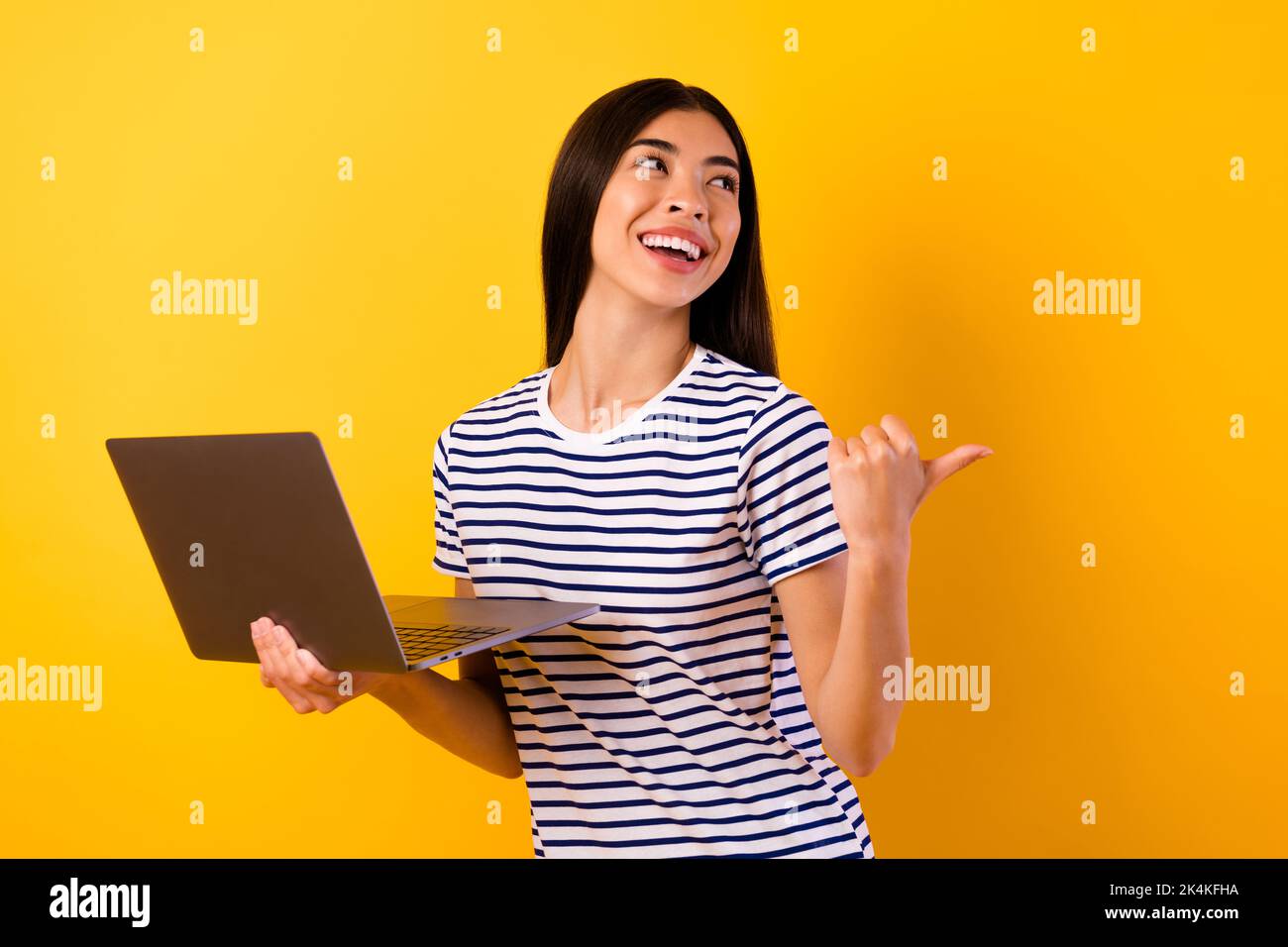 Photo of cheerful vietnamese girl look indicate finger empty space hold ...