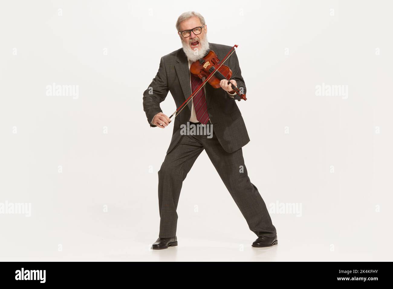 Excited senior man, musician playing violin isolated over white studio ...