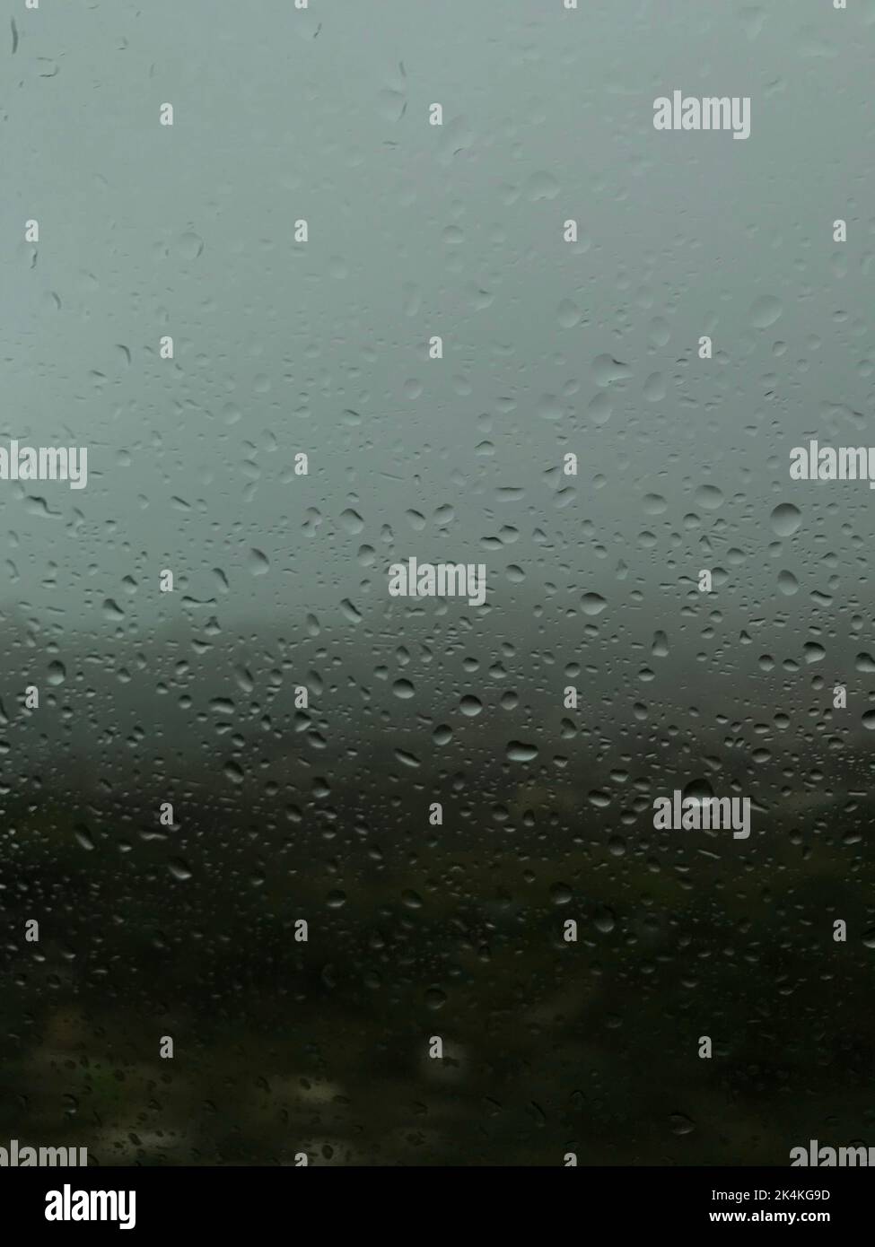 The vertical view of raindrops on the glass creates a relaxing ...
