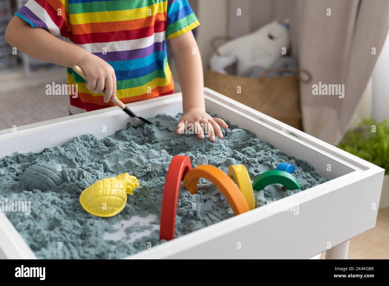 Overjoyed male kid playing kinetic sand early development education ...