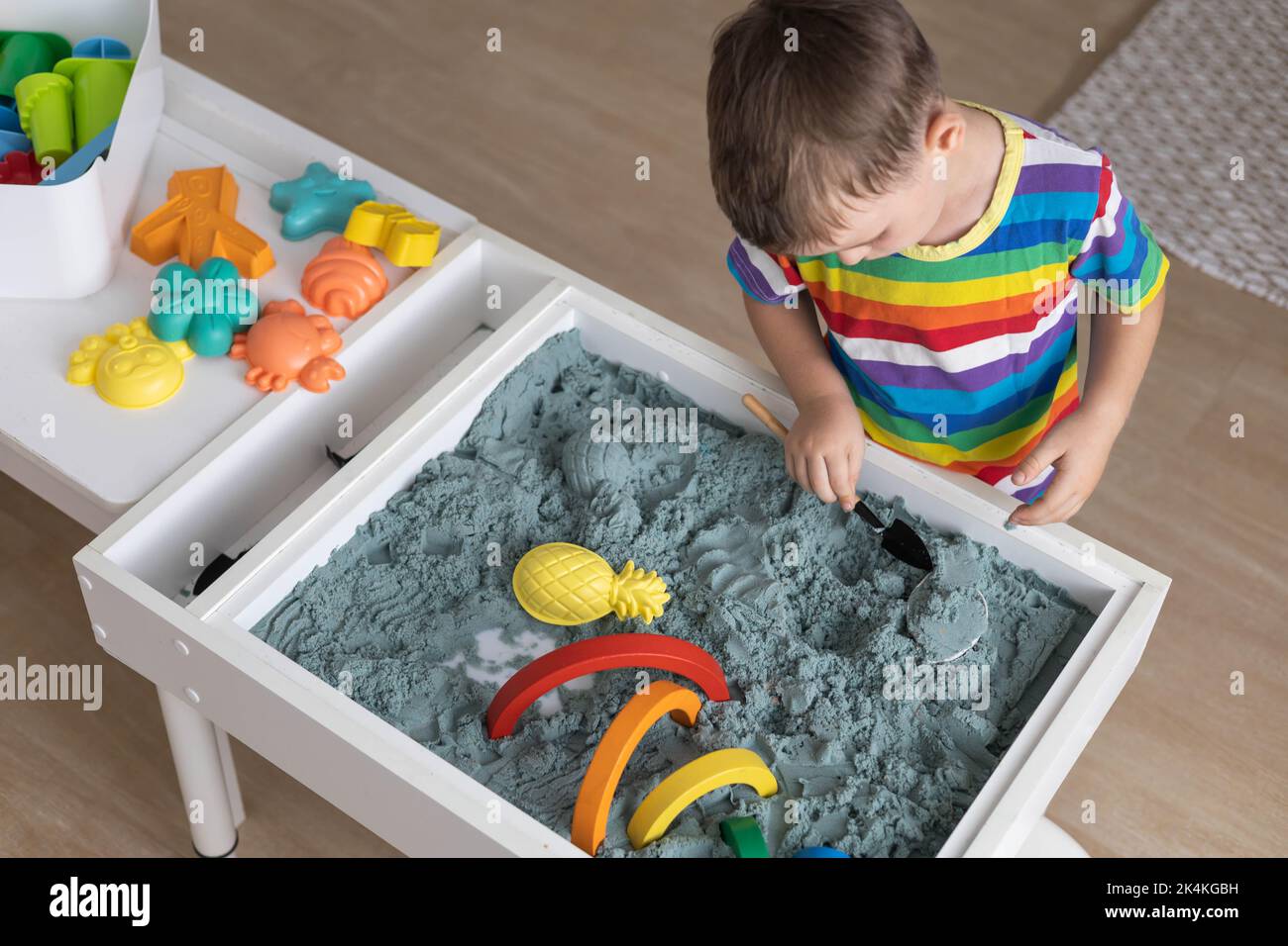 Overjoyed male kid playing kinetic sand early development education ...