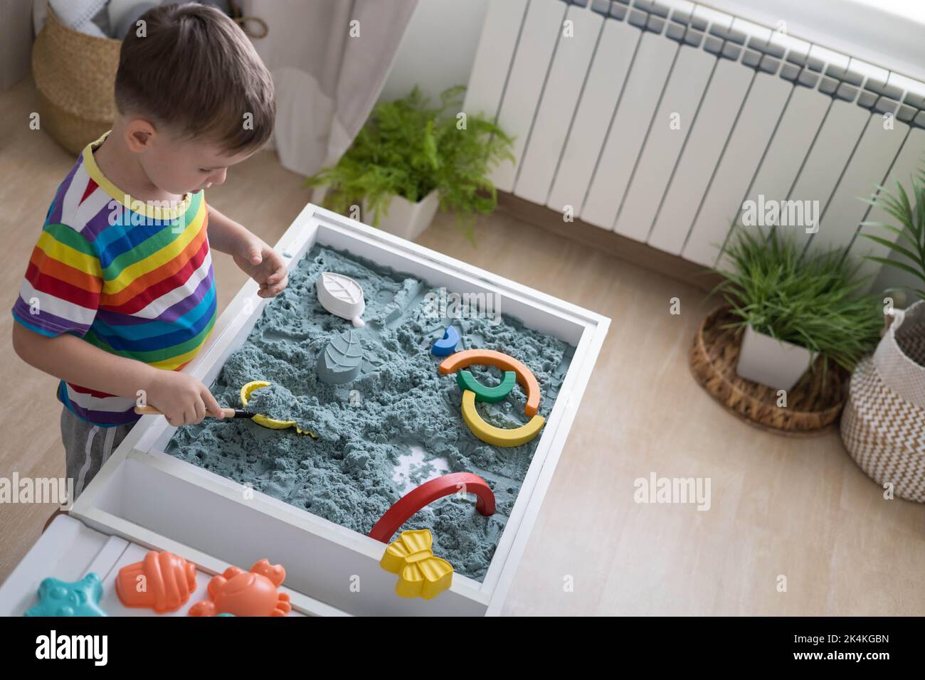Overjoyed male kid playing kinetic sand early development education ...