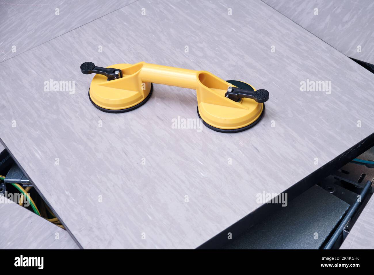 Yellow handheld device with vacuum suction cups for lifting floor ...