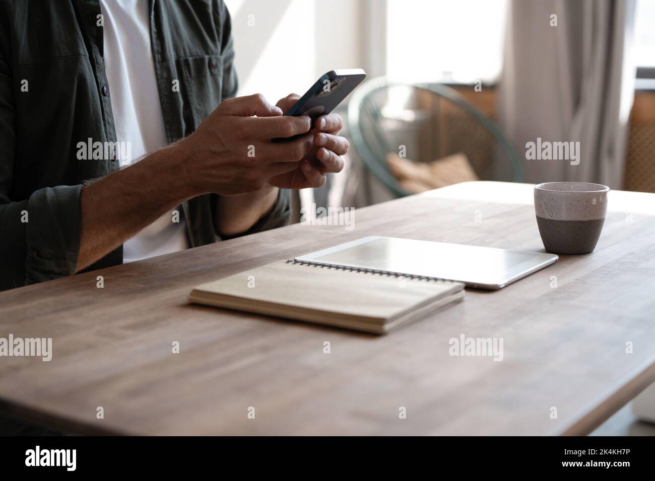 Young employee at workplace using mobile phone, checking social media ...