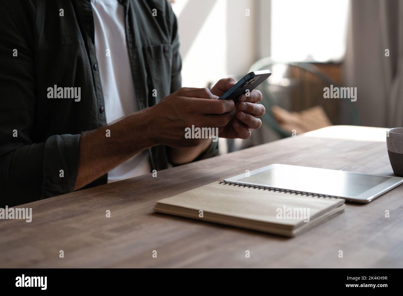 Young employee at workplace using mobile phone, checking social media ...