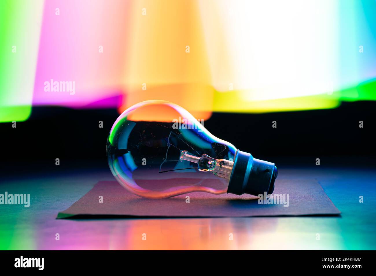 The close-up view of a lamp bulb laying over black paper under the ...