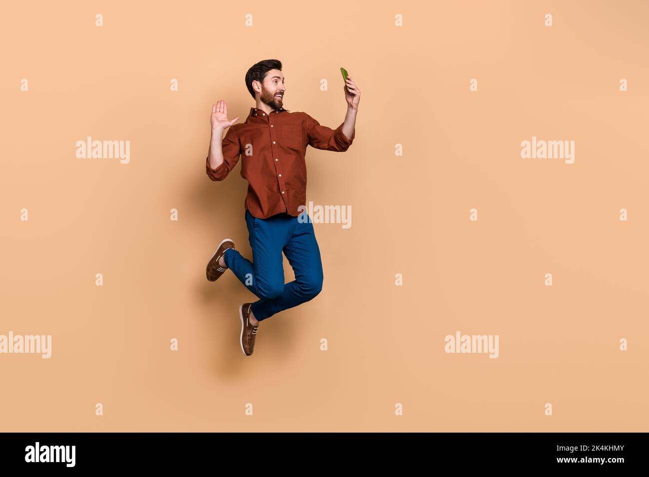 Full length portrait of handsome guy jumping arm palm waving hi ...