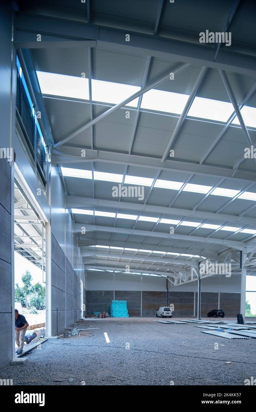 two people walking, in an industrial building repair, all white, steel ...