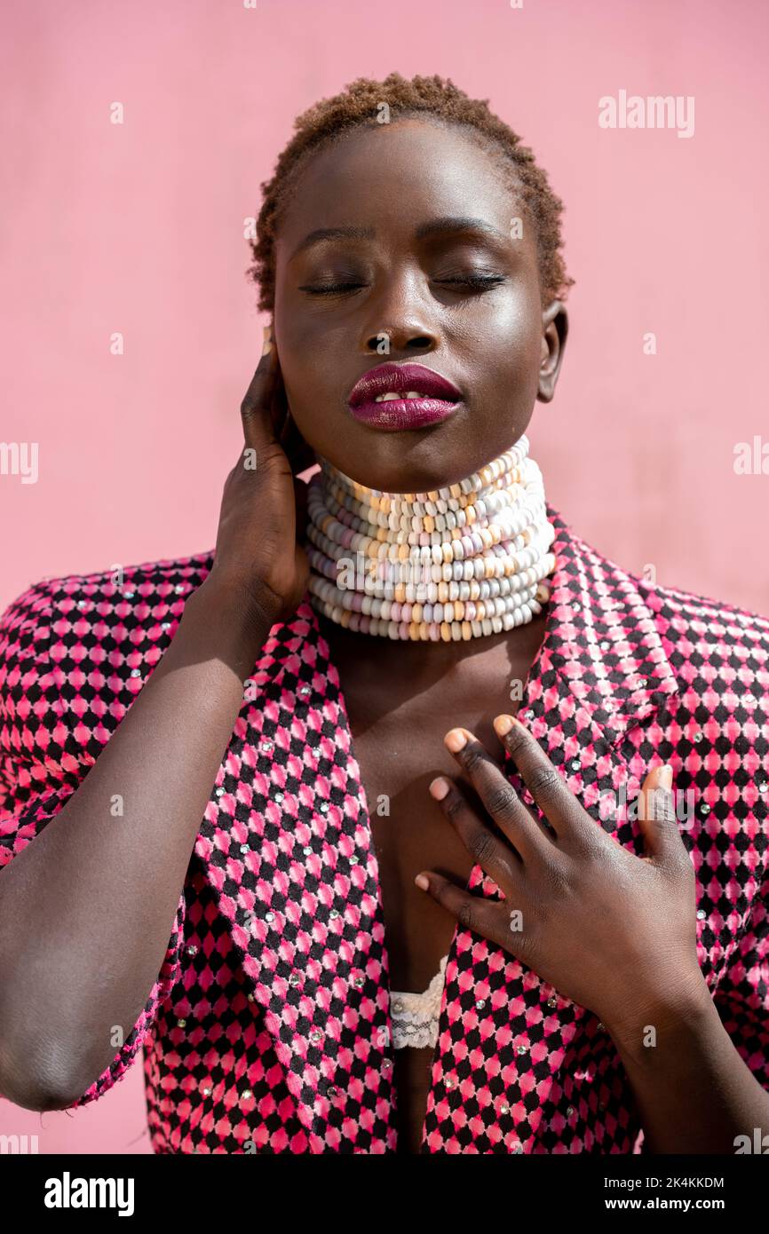 African girl wearing a candy necklace. Pink background Stock Photo - Alamy
