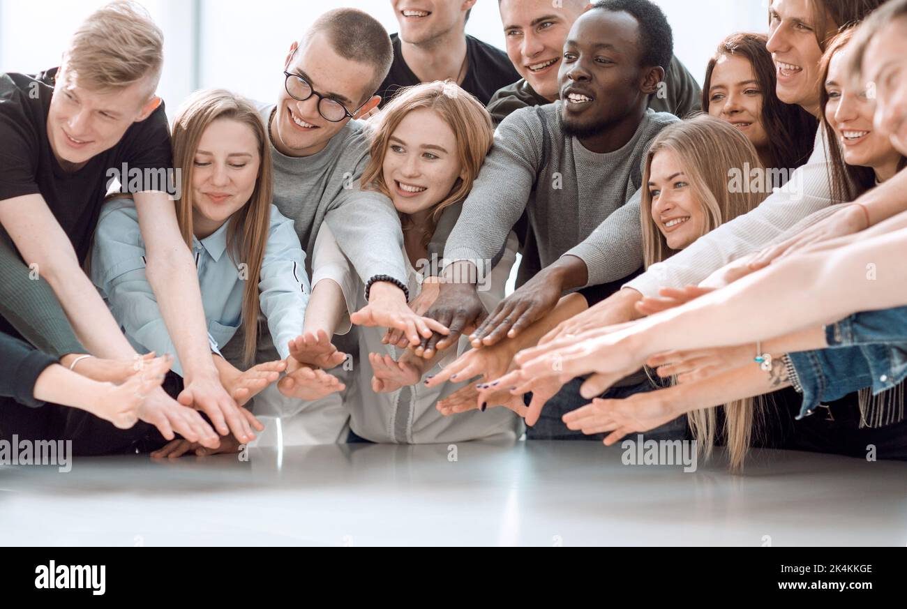 group of smiling young people joining their hands Stock Photo - Alamy