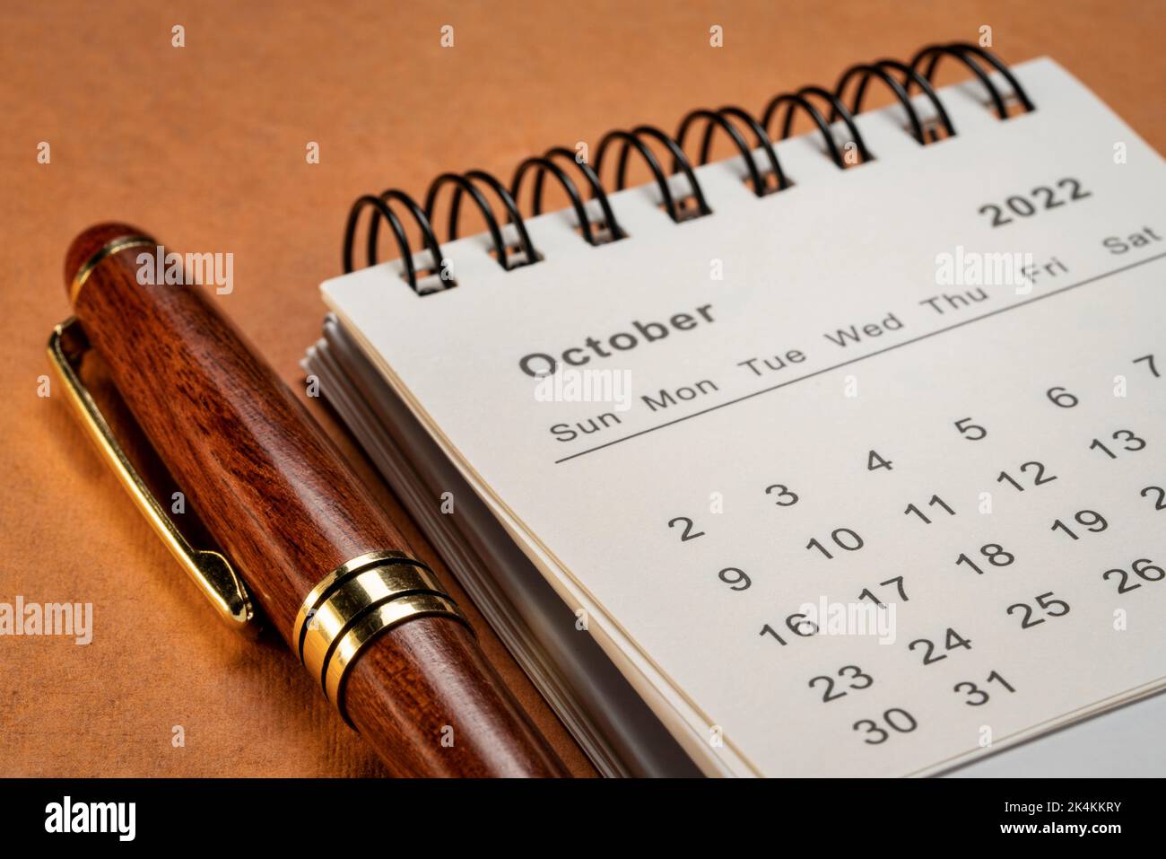 October 2022 - closeup of a small desktop calendar with a pen, time and ...