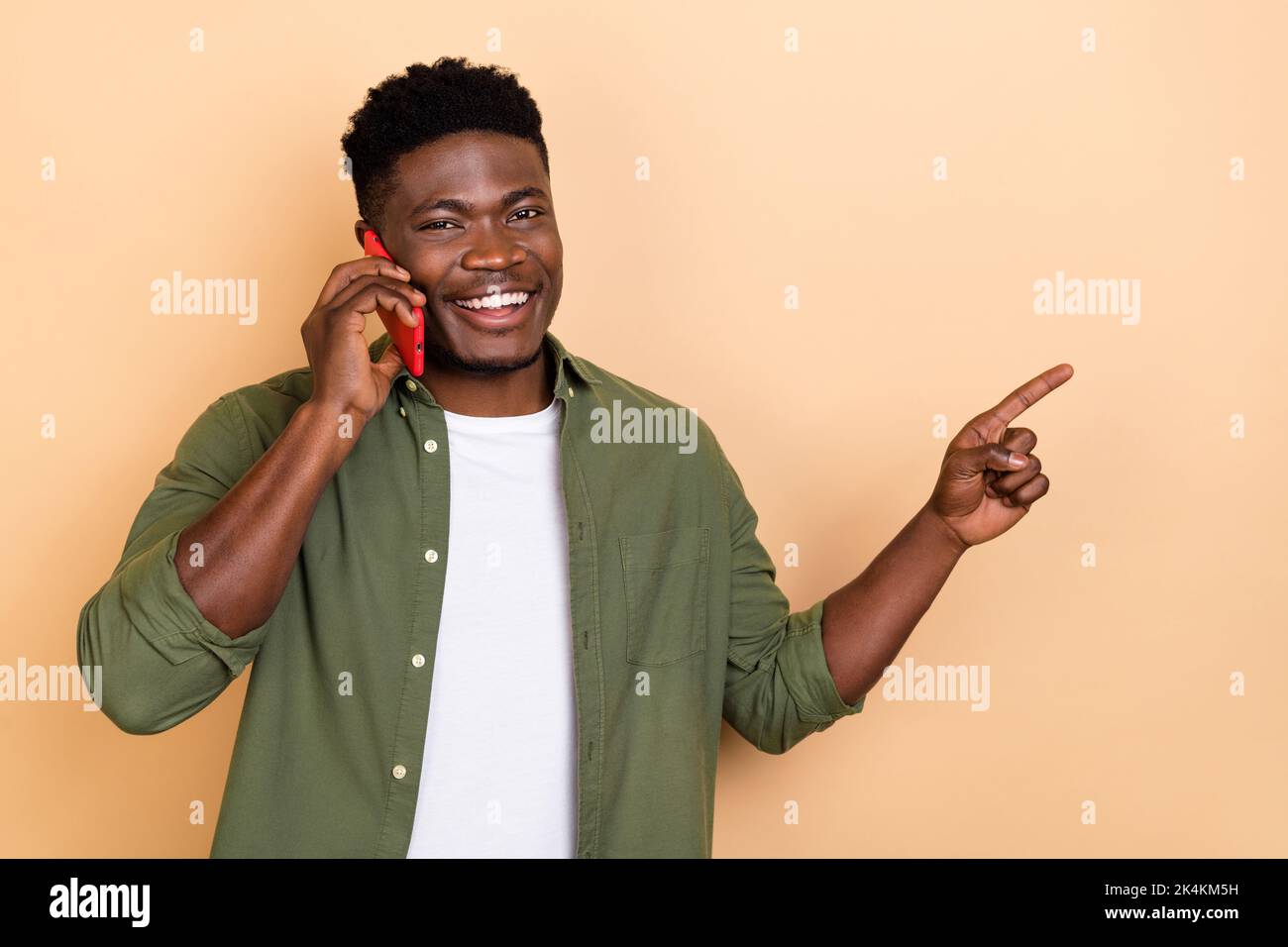 Photo of impressed millennial brunet guy talk telephone index promo ...