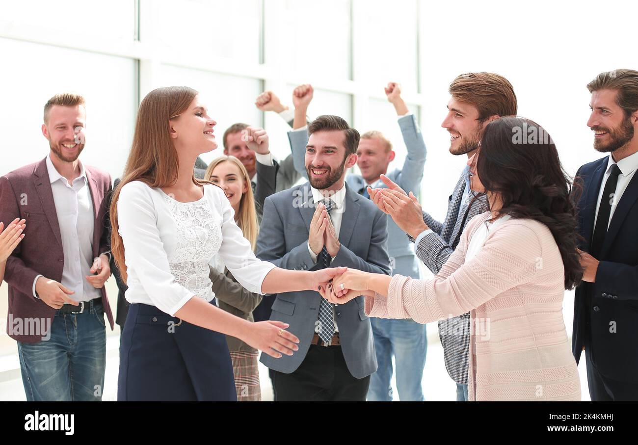 happy young employees greeting their young colleague Stock Photo - Alamy