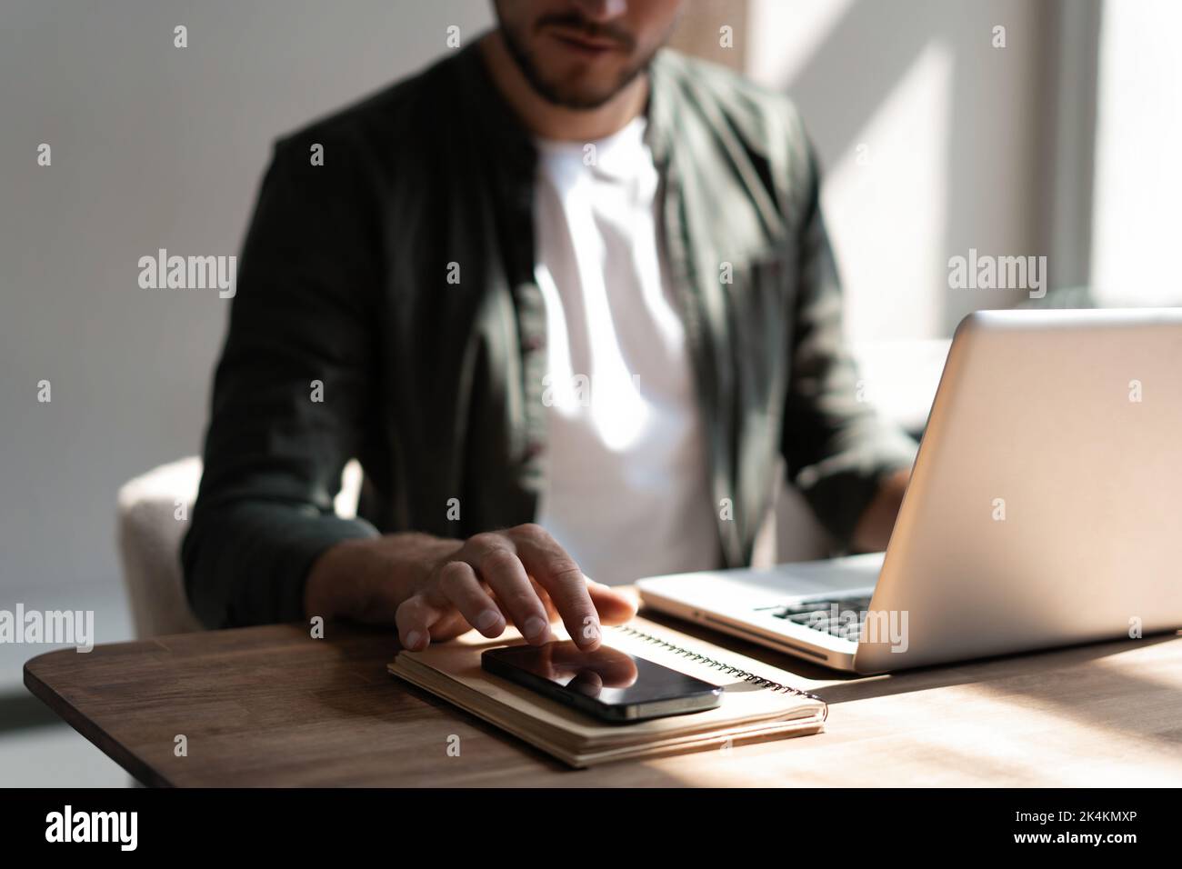 Young employee at workplace using mobile phone, checking social media ...