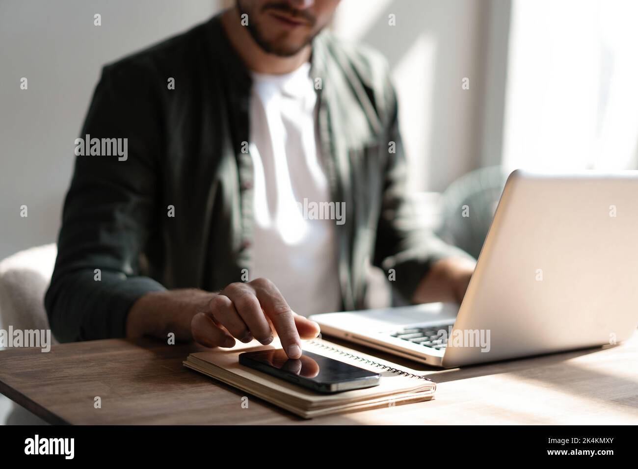 Young employee at workplace using mobile phone, checking social media ...