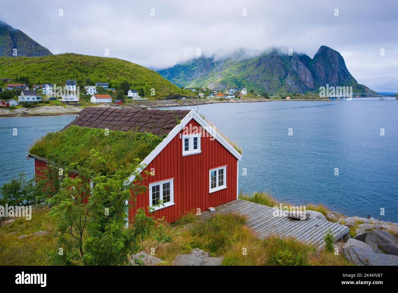 Traditional peat roof red wooden house on the coastline of Reinefjorden ...