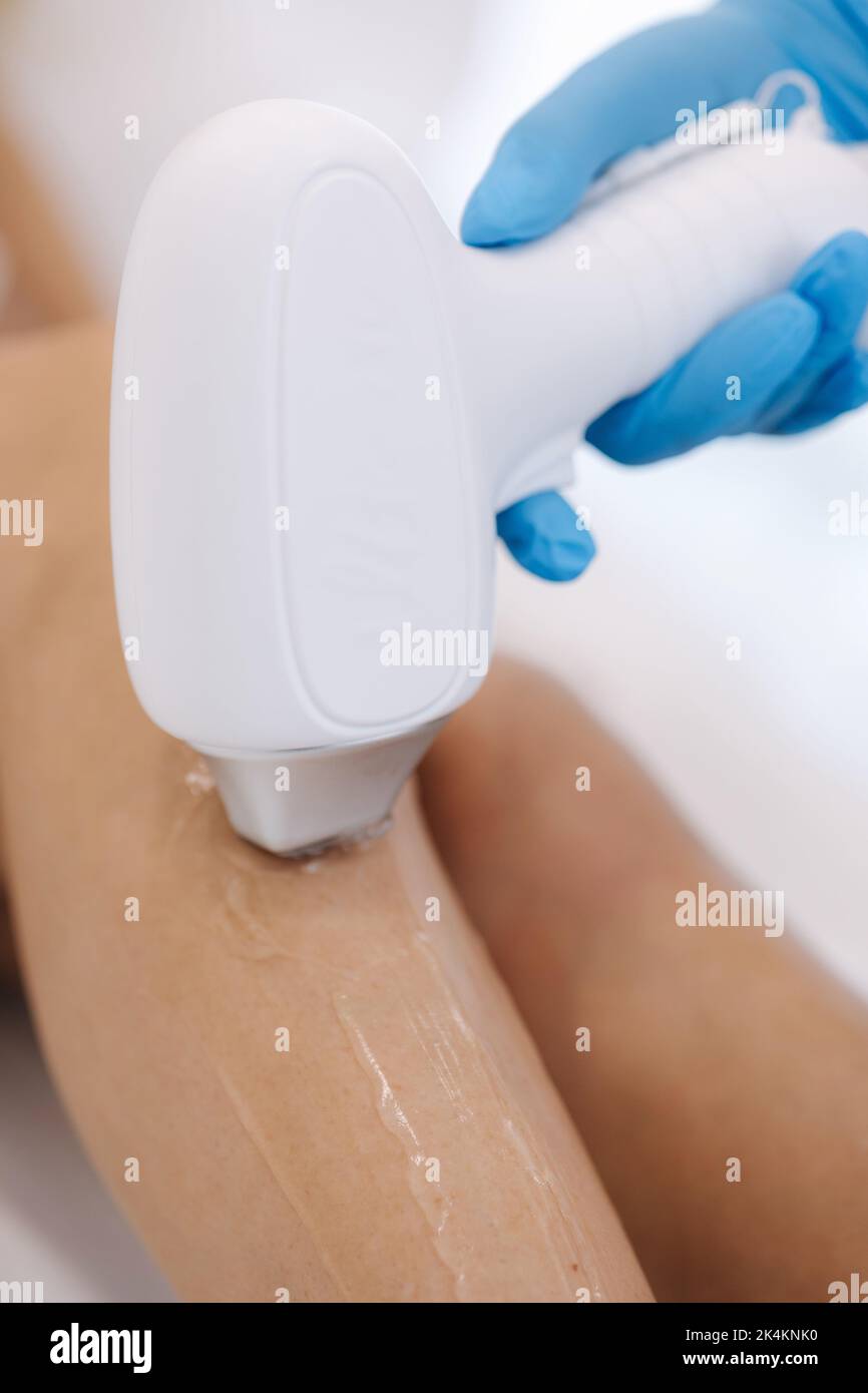 Beautician doing epilation on beautiful woman's leg in beauty center ...