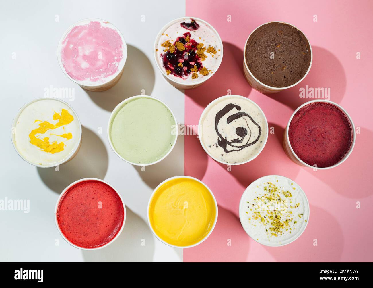 A top view of ice-creams with different tastes in paper mugs on a white ...