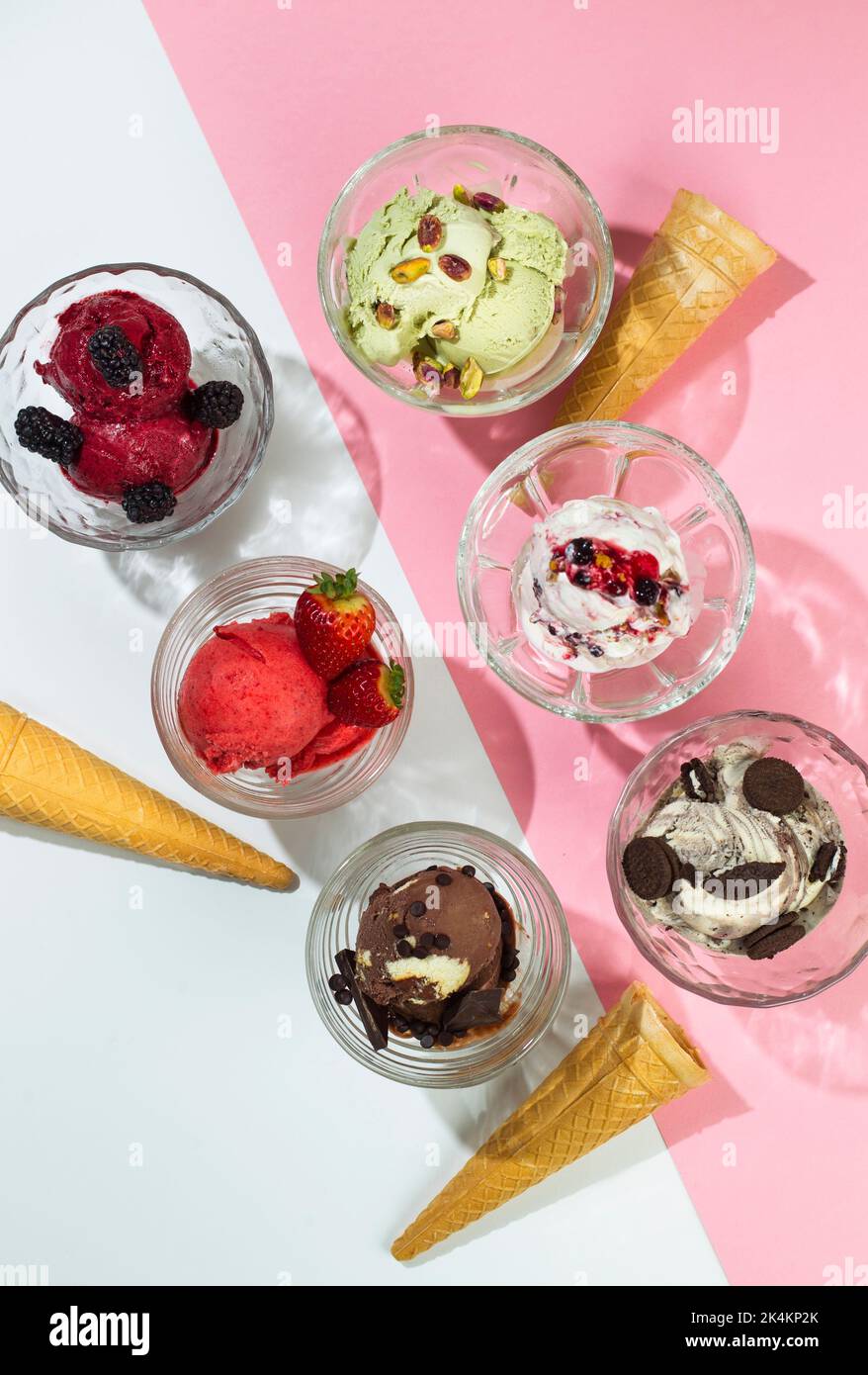 A top view of ice-creams with different tastes and cones in glasses on ...