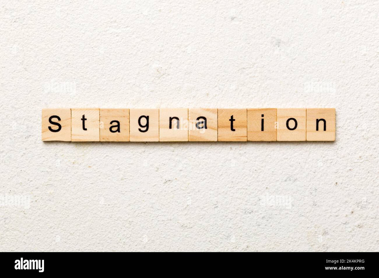 stagnation word written on wood block. stagnation text on cement table ...