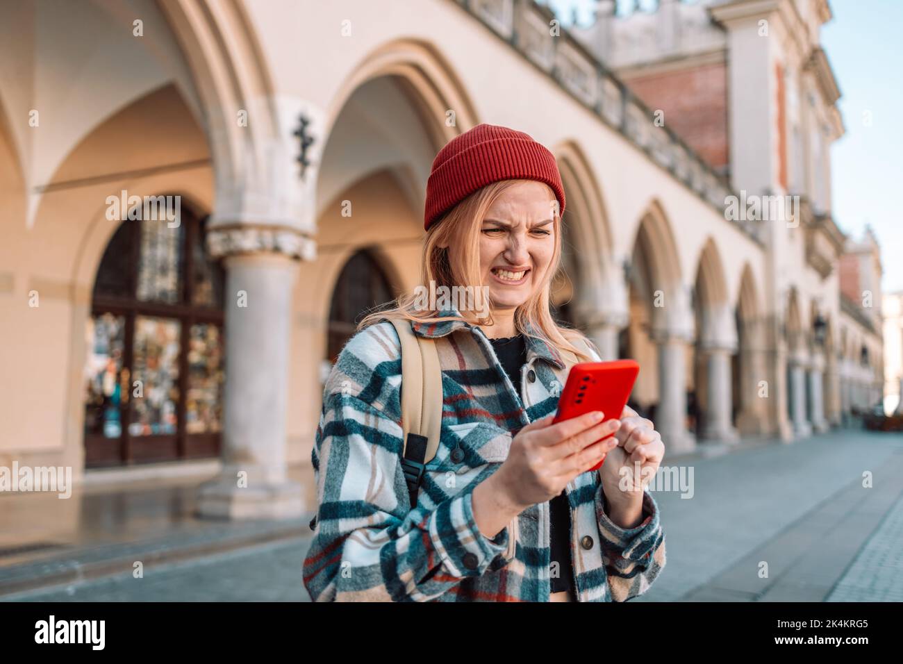 angry sad woman with blonde hair annoyed by something while using phone ...