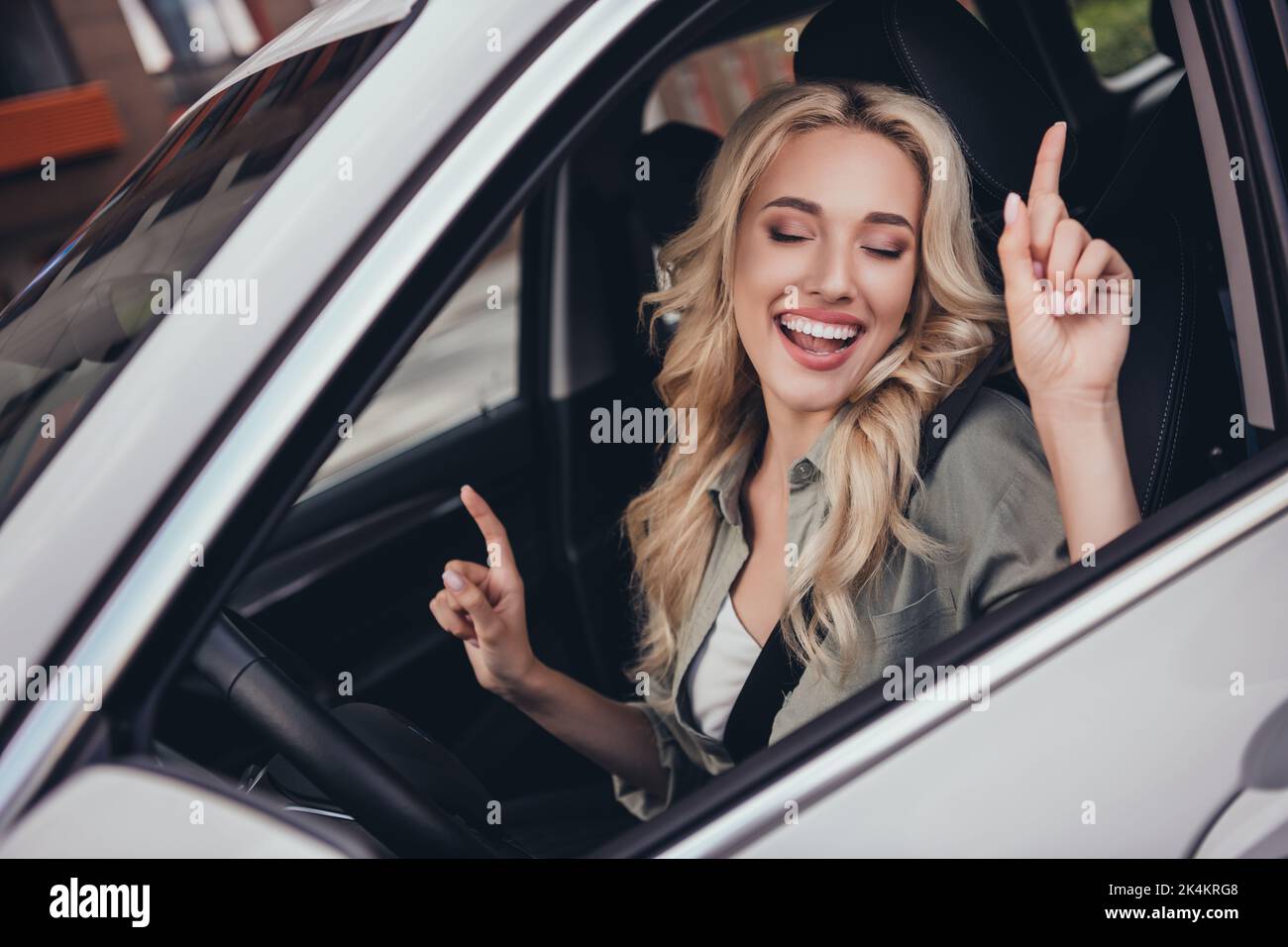 Photo of sweet pretty lady driver ride auto outside town listen sound ...