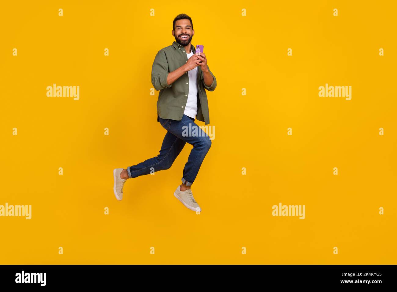 Full length photo of pretty cute man wear khaki shirt typing modern ...