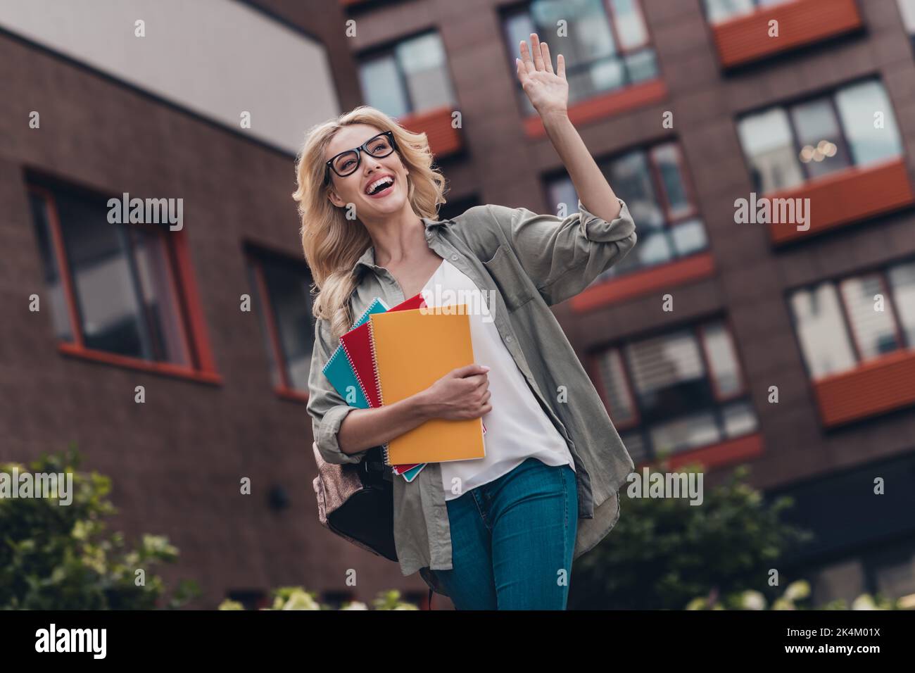 Photo of positive pretty lady raise open arm palm waving hi walk ...