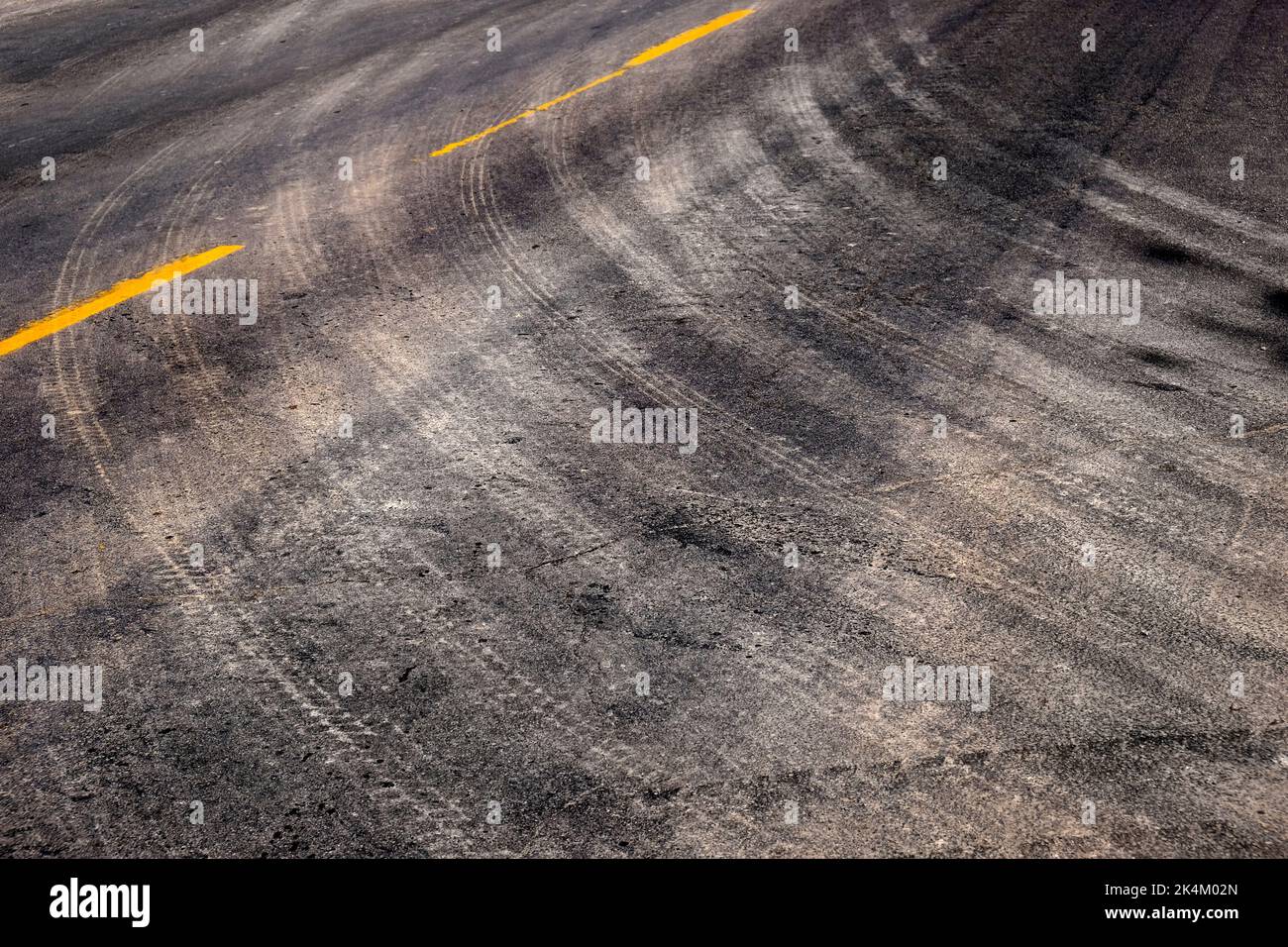 Tire track marks turning on road with yellow stripe lines Stock Photo ...