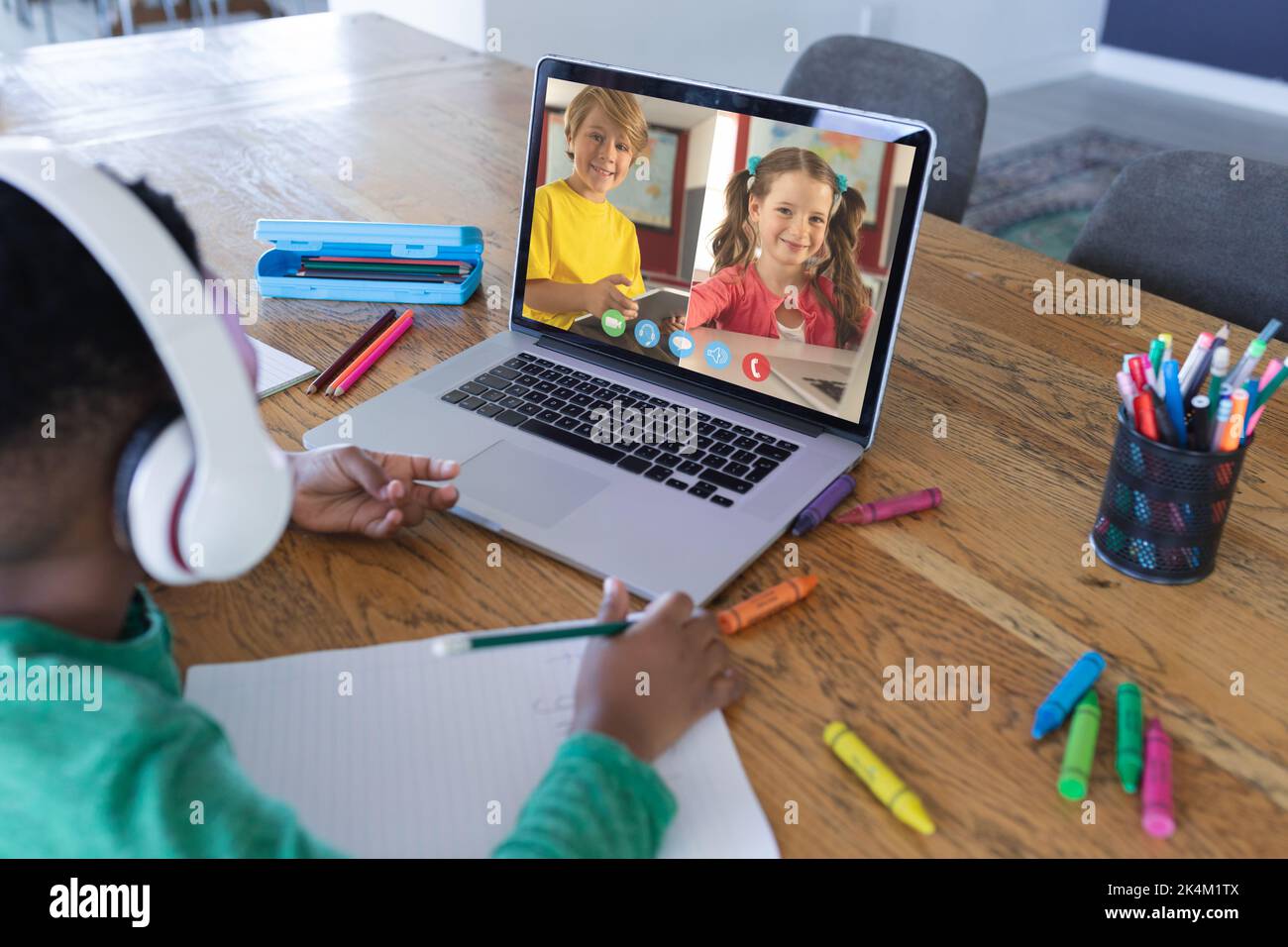 African american boy using laptop for video call, with caucasian ...