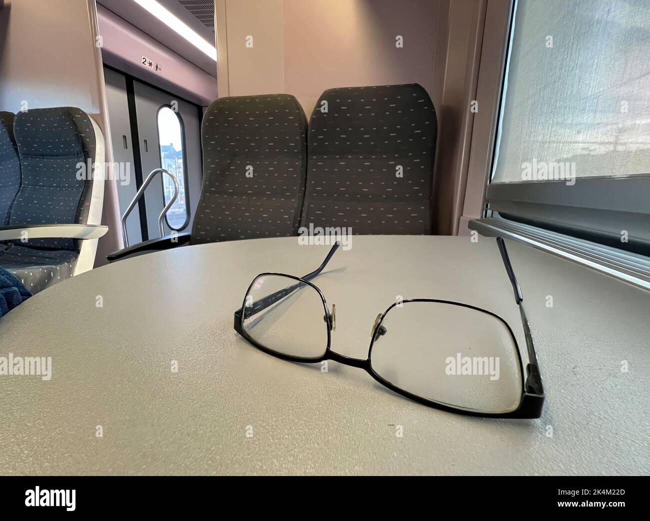 Closeup on a glasses of commuting passenger on a reading table inside a ...