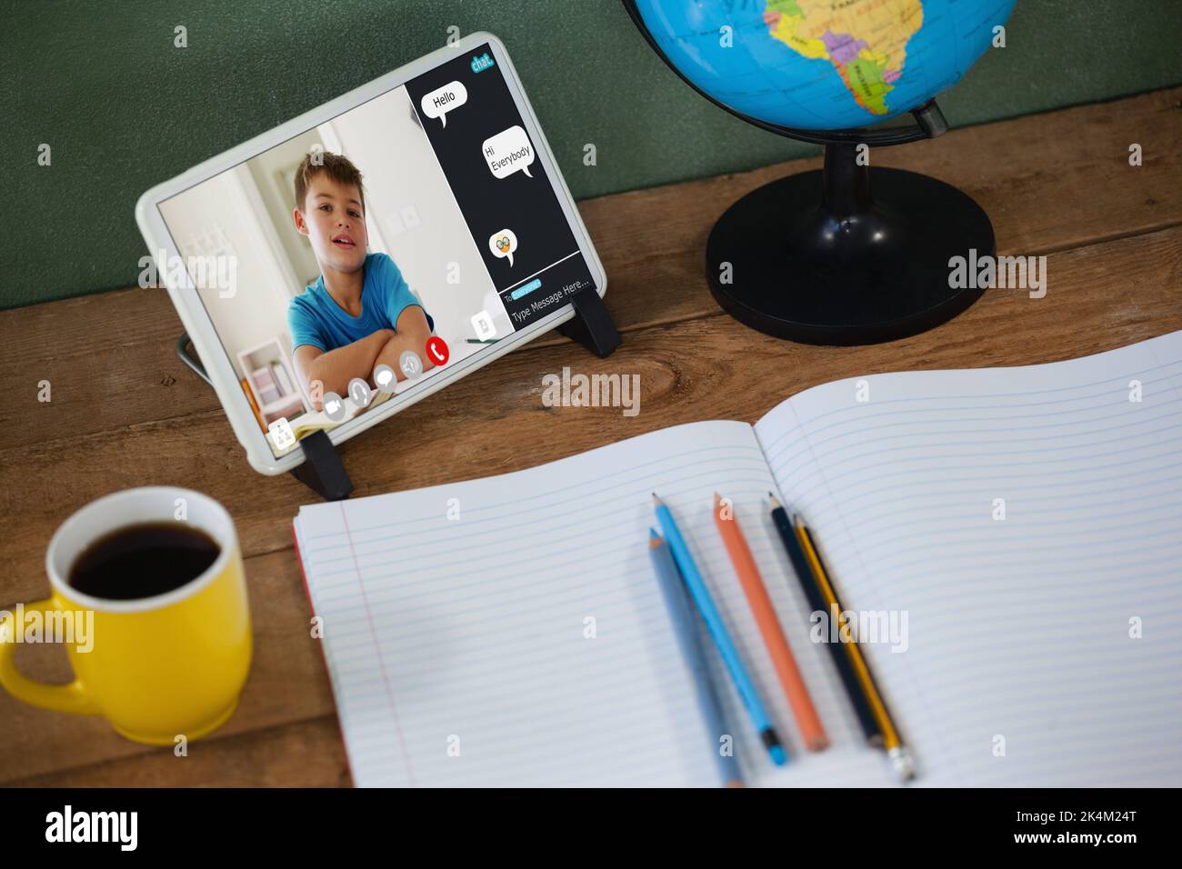 Smiling caucasian elementary school pupil during class on tablet screen ...