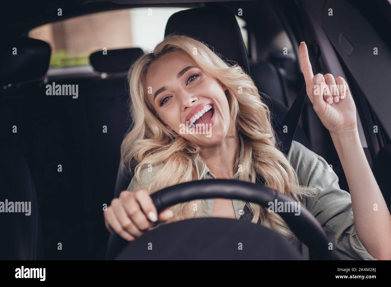 Photo of cheerful overjoyed person sitting driver seat hold wheel point ...