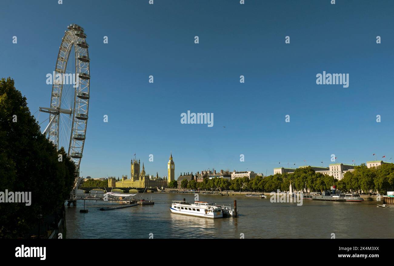 Sunny summer blue sky view along River Thames past London Eye and river ...