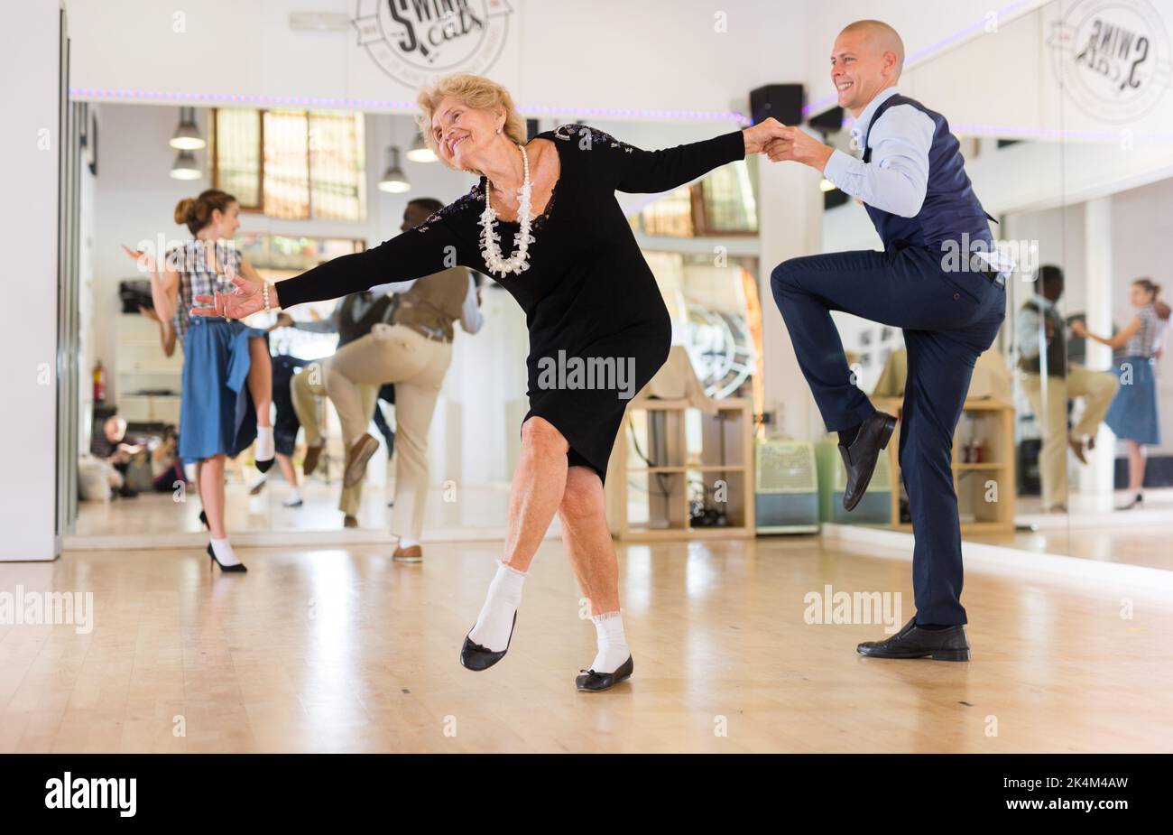 Mature woman learning to dance lindy hop with younger man Stock Photo ...