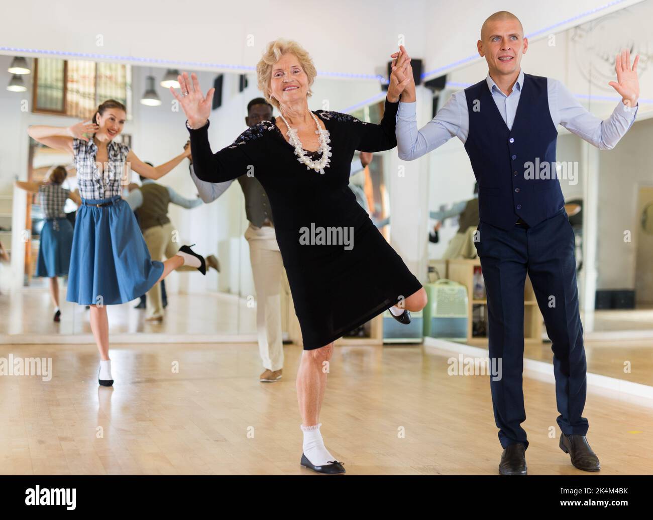 Mature woman dancing swing with young man Stock Photo - Alamy