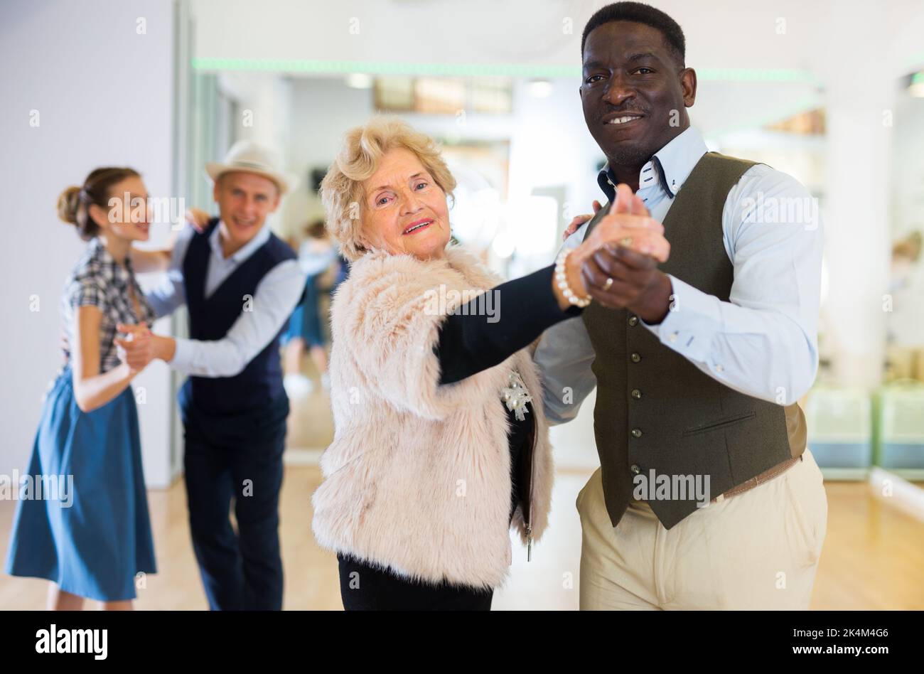 Elderly woman learning ballroom dancing in pair in dance studio Stock ...