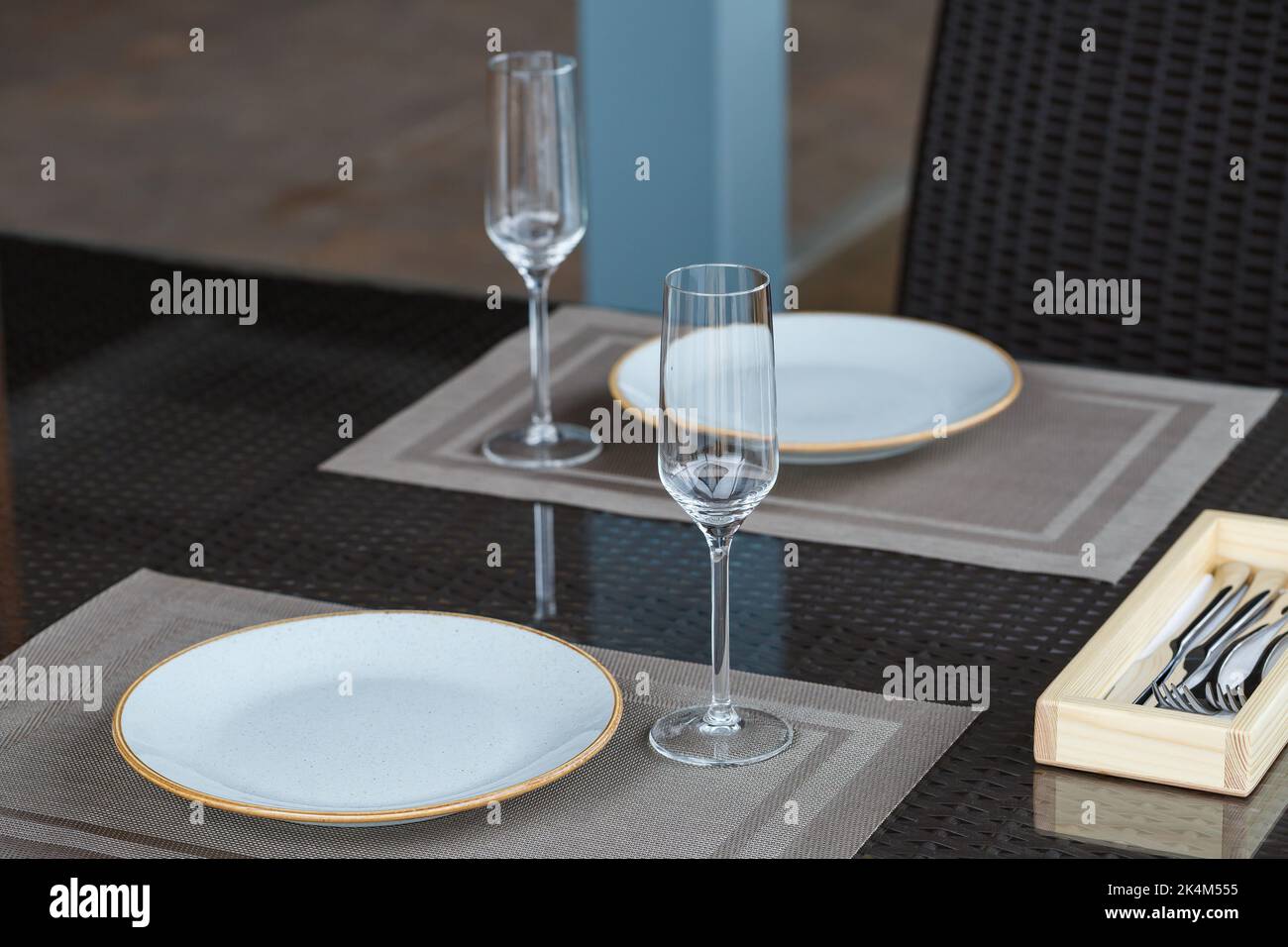 Served table in a restaurant for two. Blue plates for food, two glasses ...