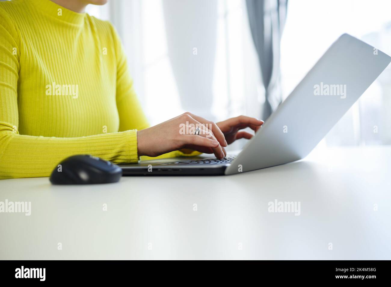 Girl typing text on laptop keyboard at home. Young woman working on ...