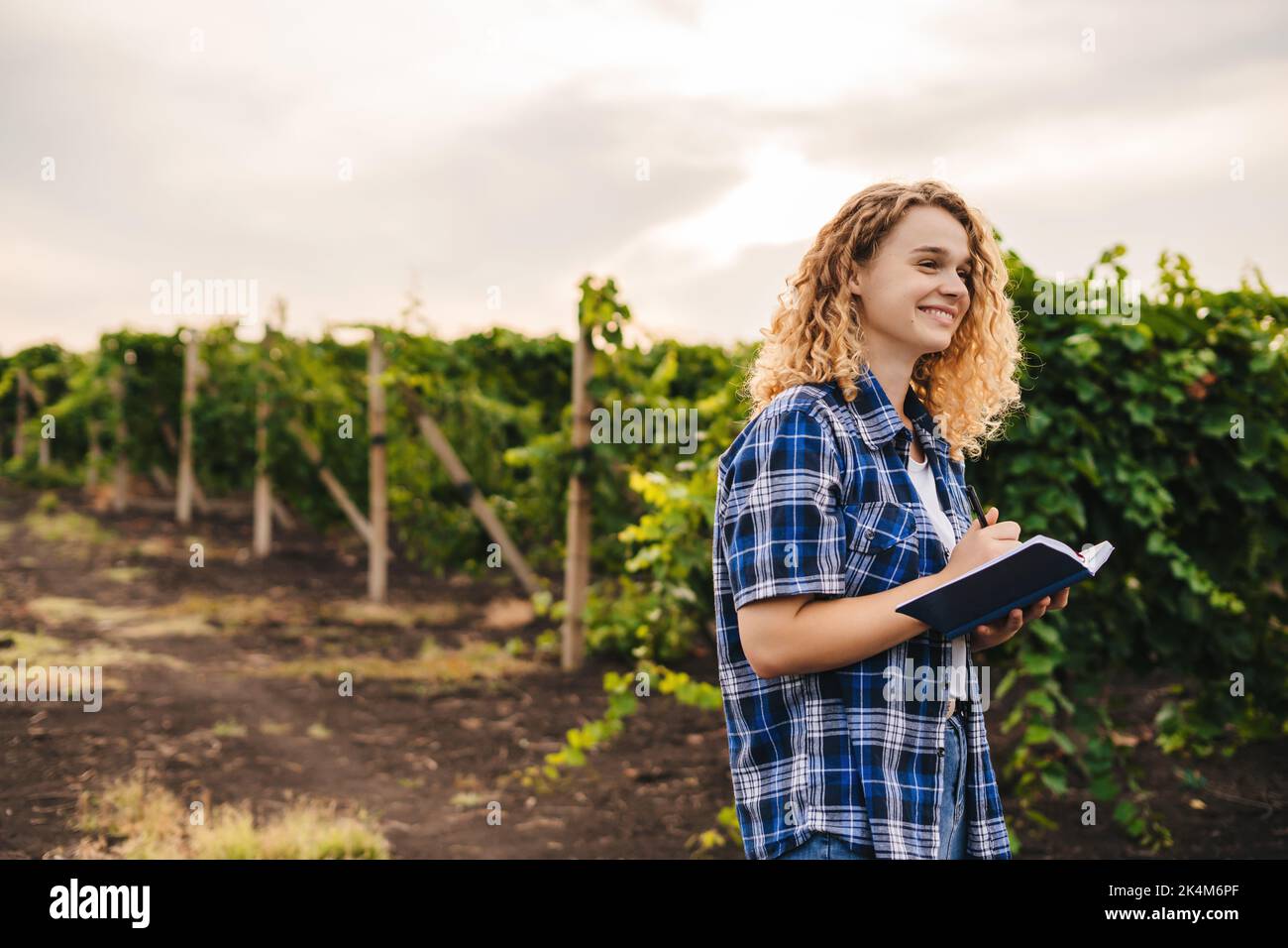 Woman engineer holding a note book examining agricultural plantation ...