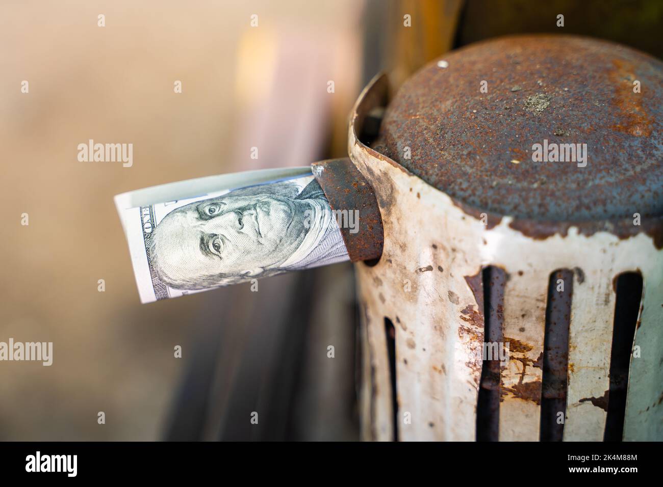 A hundred dollar bill rolled into a tube sticks out of the exhaust pipe ...